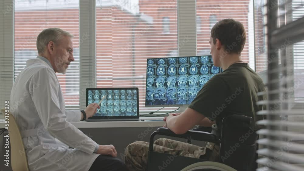 Medium shot of young Caucasian army officer in wheelchair sitting in ...