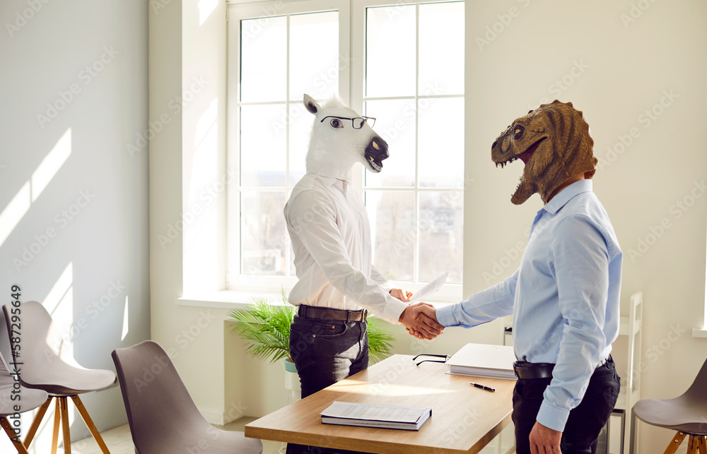 Happy funny colleagues business men shaking hands at meeting wearing ...