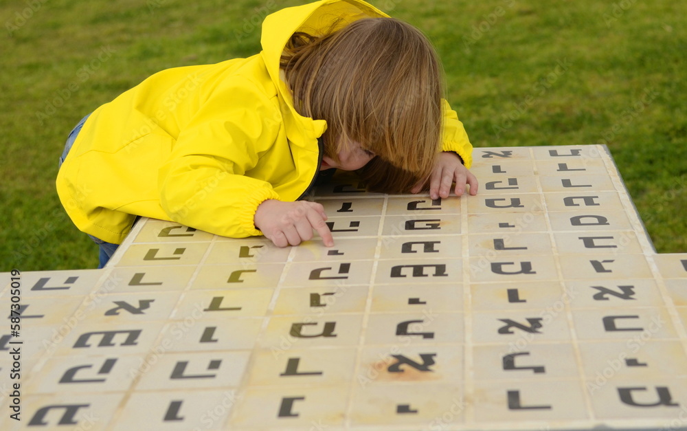 Little boy looks up the Hebrew alphabet. Learning with play. Hebrew ...