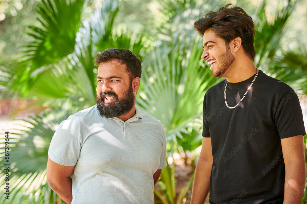 Two funny indian men laughing and speak Hindi in public park green palm ...