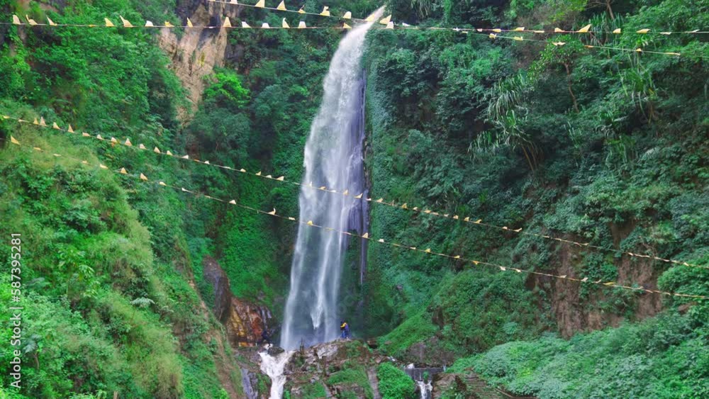 Parallax of large waterfall dropping off a steep cliff near lush green ...