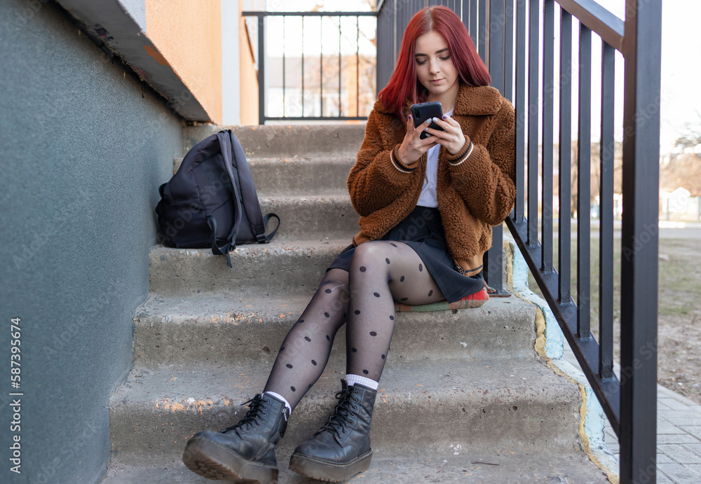 Upset and depressed girl holding a smartphone while sitting on the ...