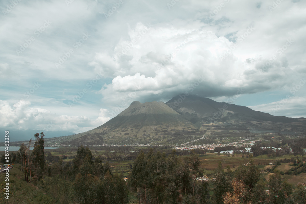Tall strata volcano sticking up in the middle of a mountain range ...