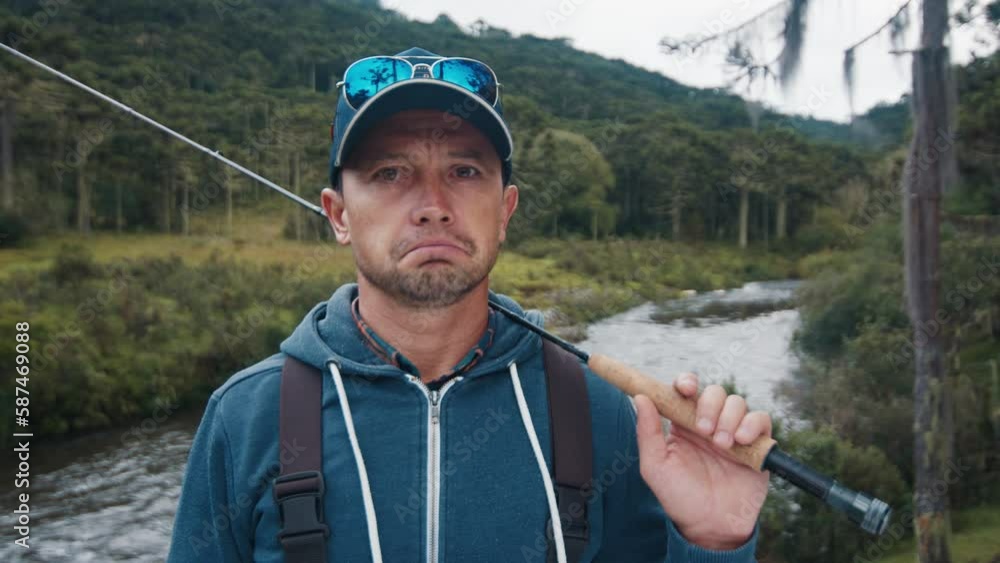 Video Stock Unlucky angler. Sad fisherman stands by the river with rod ...