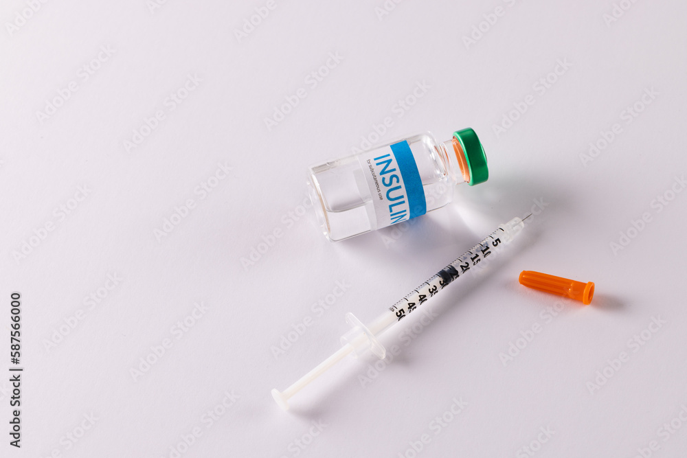 Insulin vial and uncapped syringe on white background with copy space ...