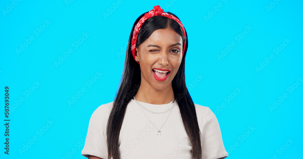 Happy woman, face and wink on blue background, laughing and flirting in ...