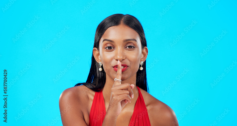 Secret, face and woman with finger on lips in studio, blue background ...
