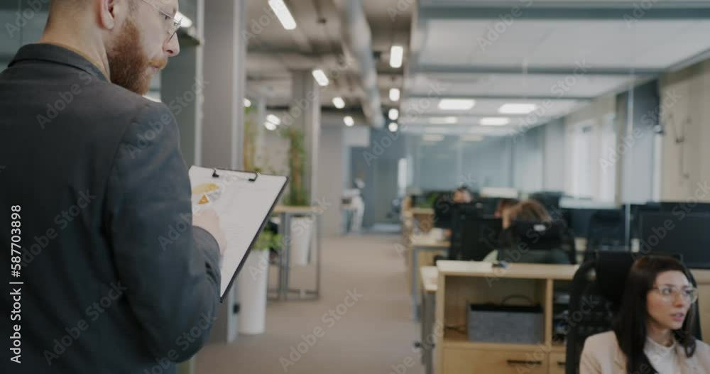 Back view of businessman walking in office waving hand to collegue and ...