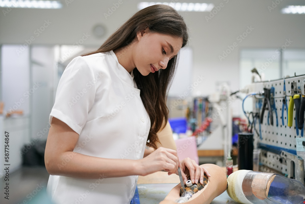 Production of a prosthetic leg. A woman creates part of the leg. An ...