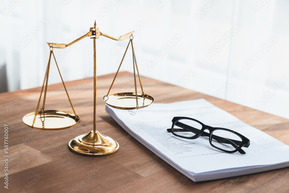 Shiny golden balanced scale and pile of legal paper on desk in lawyer ...