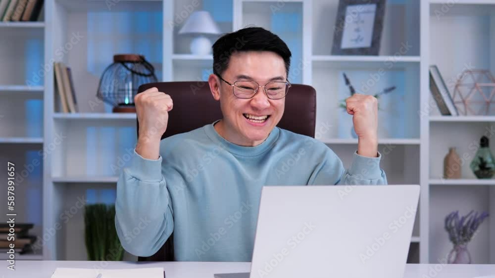 Cheerful elated chinese businessman is celebrating victory. Man ...