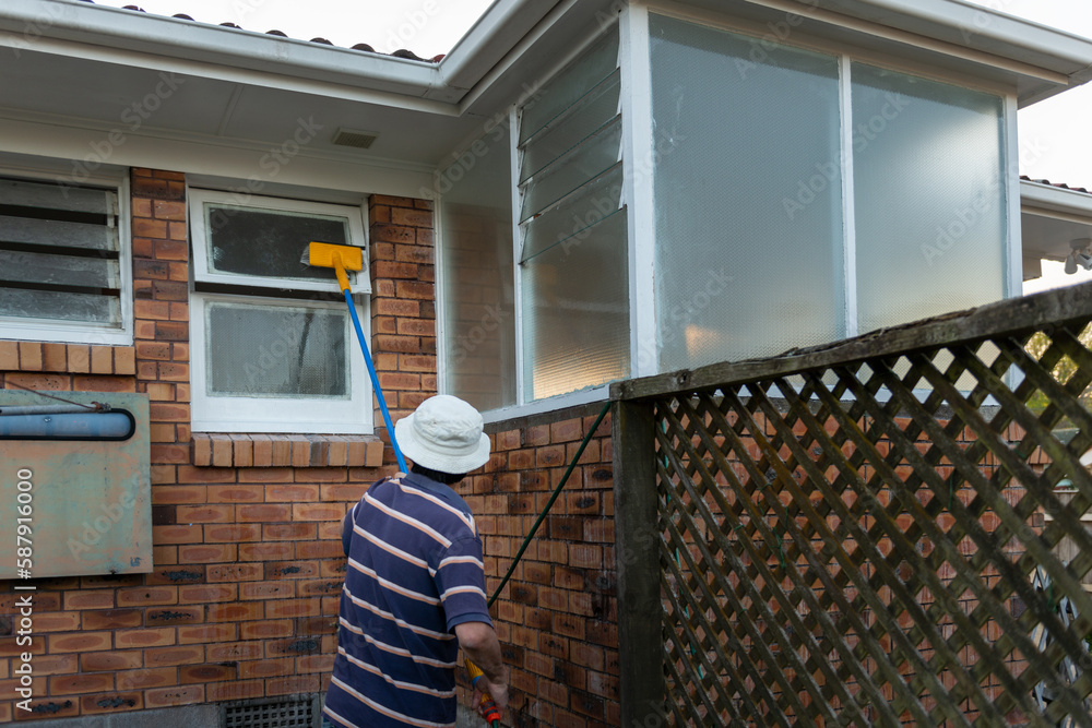 Man washing outside window with long pole and brush. Auckland Stock ...