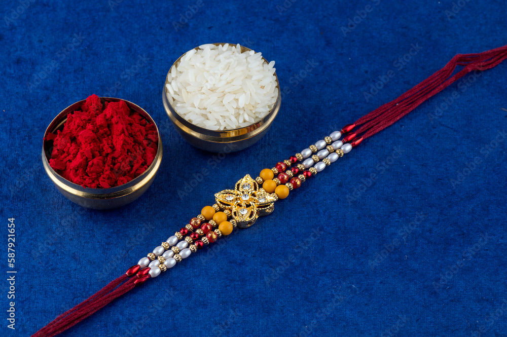 Indian festival: Raksha Bandhan background with an elegant Rakhi, Rice ...