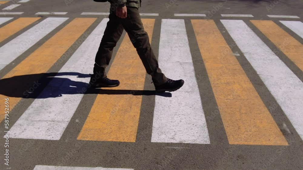 man crossing a pedestrian crossroad, side view from below, slow motion ...