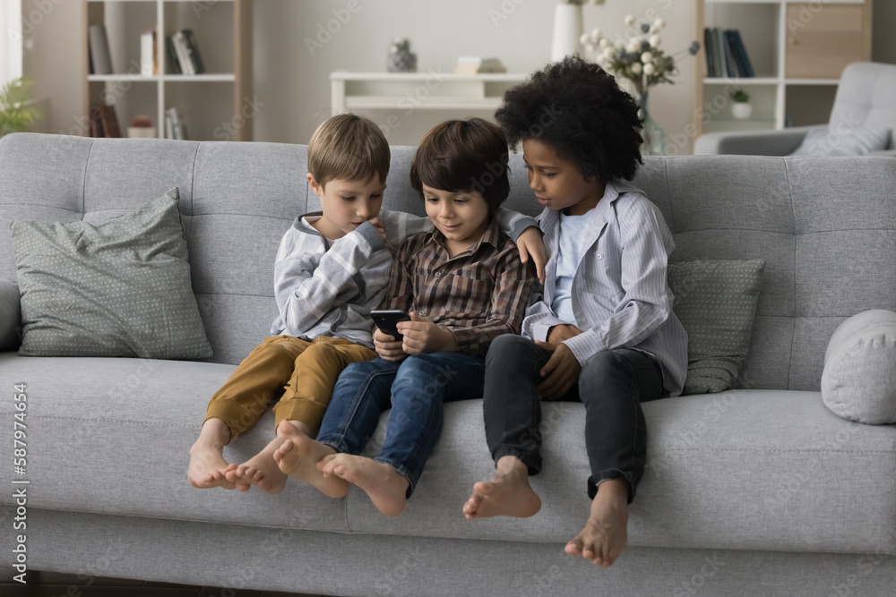 Three diverse gen Z kids using learning app mobile phone, sitting on ...