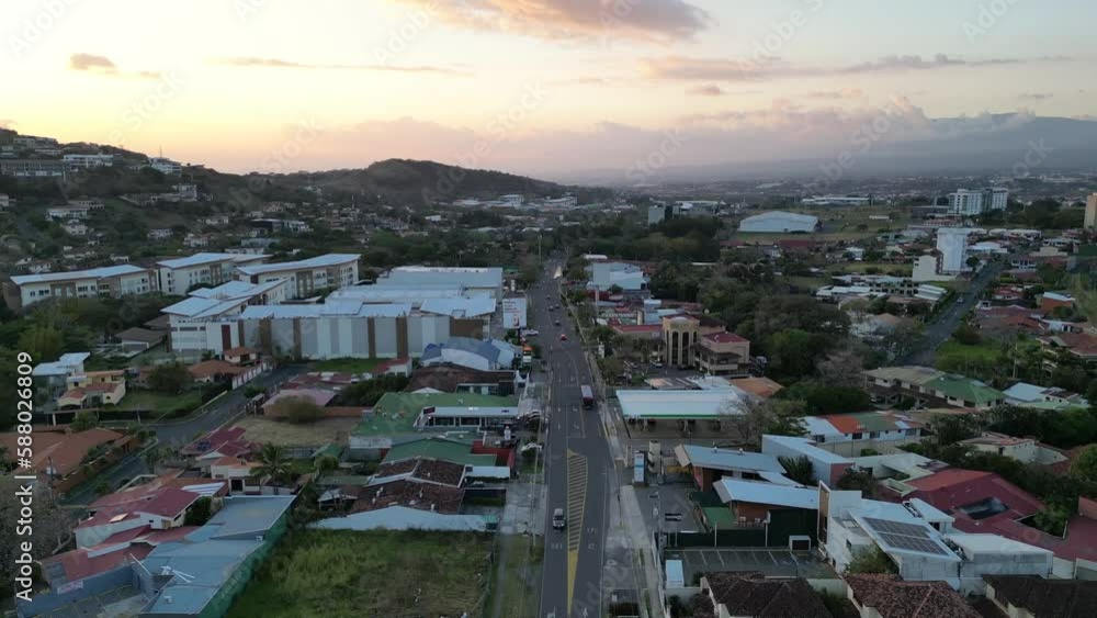 Cars driving on street through retail district in Escazu, a suburb of ...