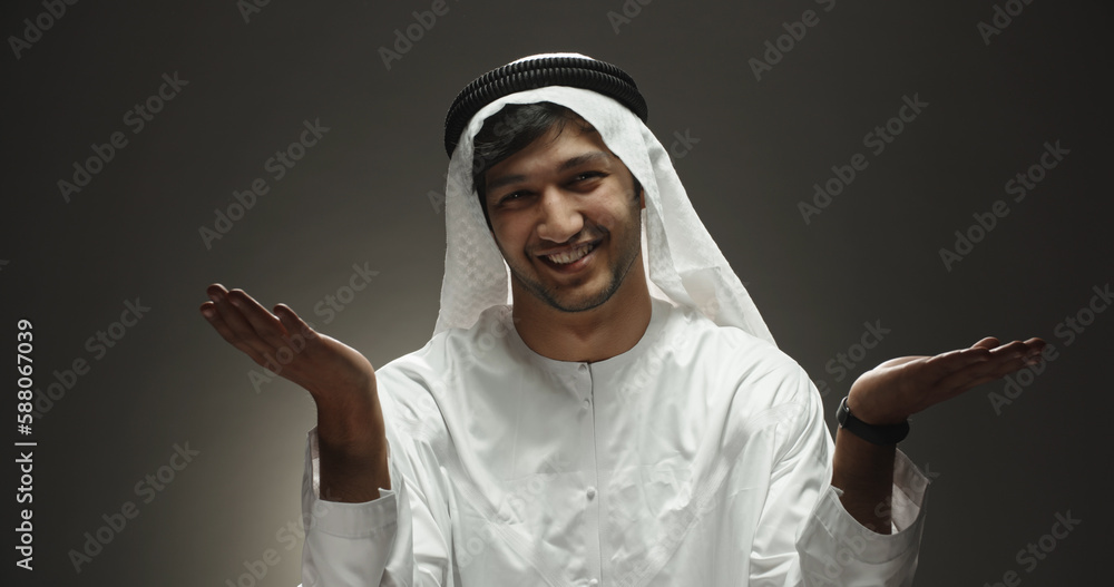Arabian man looking at camera and positively smiling, throwing his ...