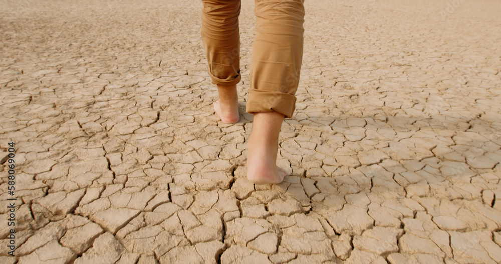 Close up shot of feet of adult man walking barefoot on bottom of dried ...