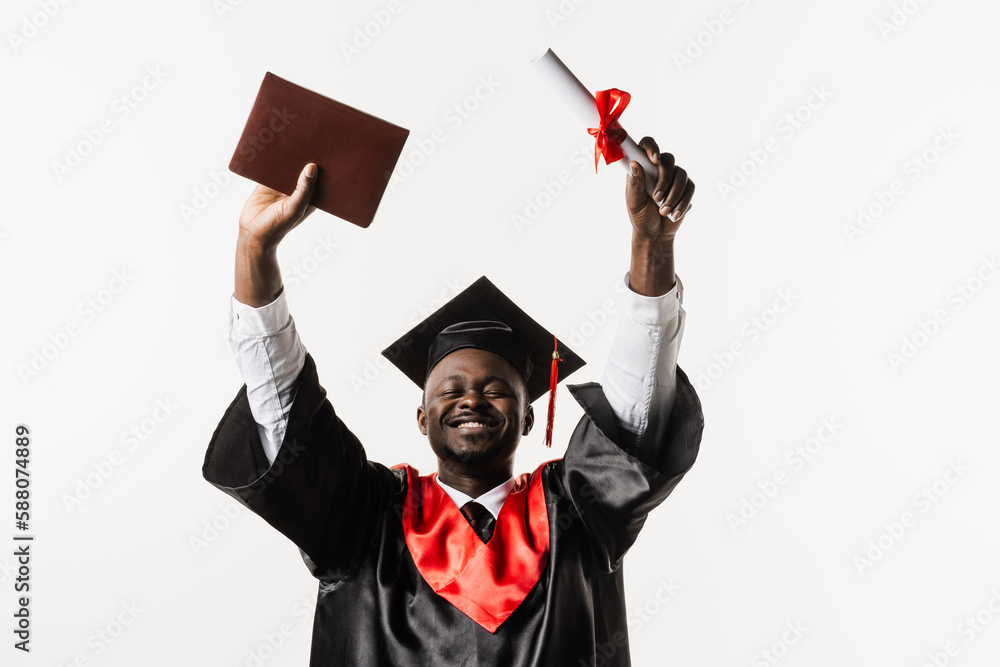Happy african student in black graduation gown and cap raises masters ...