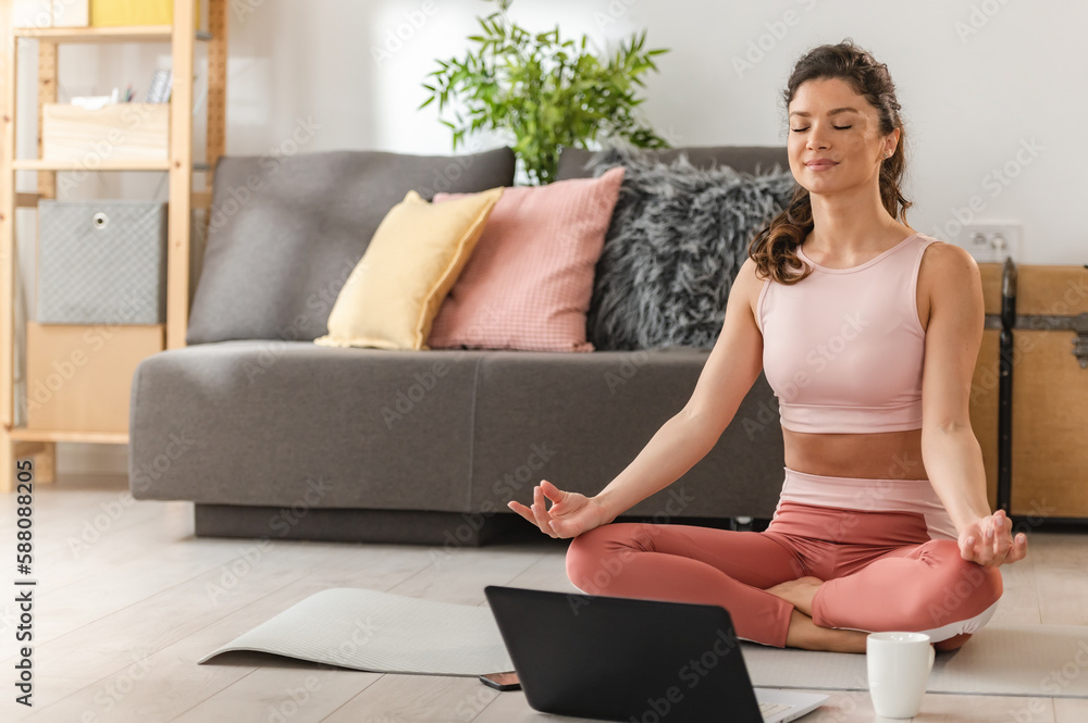 Foto de Beautiful woman practicing yoga at home. Getting fit in the ...