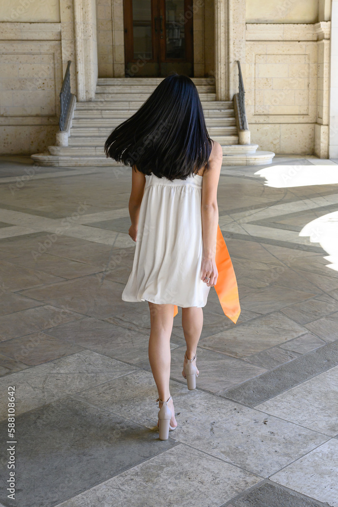 Young attractive Asian American college student, wearing gown and sash ...
