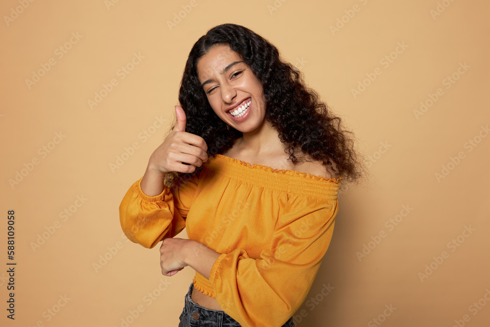 Portrait Of Pretty Cheerful Young Girl With Dark Skin And Hair Showing