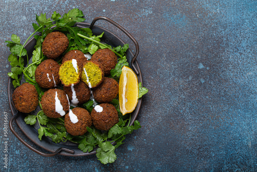 Plate of fried falafel balls served with fresh green cilantro and lemon ...