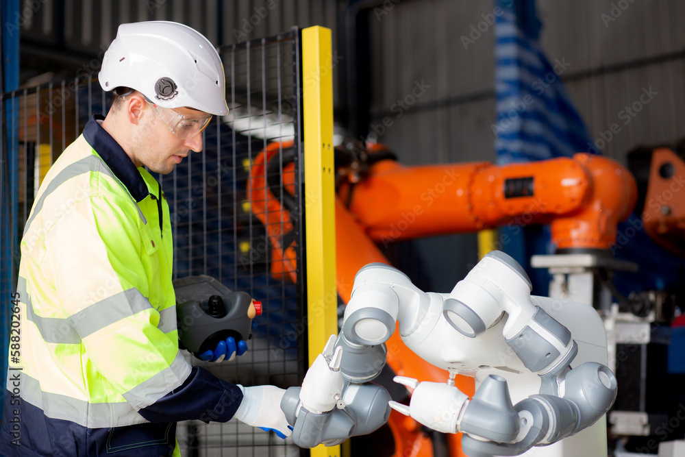 Young engineer man checking and maintenance machine robot arms ...