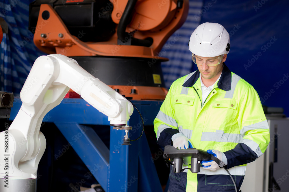 Young engineer man checking and maintenance machine robot arms ...