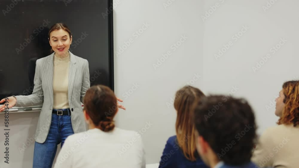 Experienced female teacher giving lecture to group of student ...