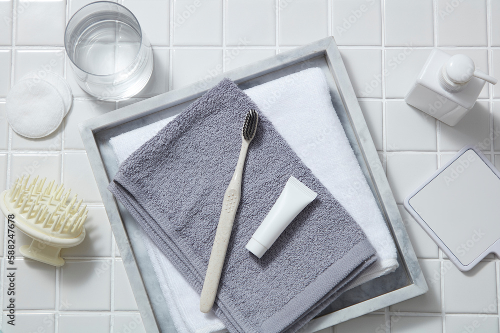 A toothbrush with a mini tube decorated on towels with mirror, pump ...