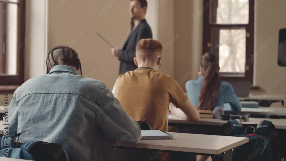 Back view waist up slowmo of Biracial male university student raising ...