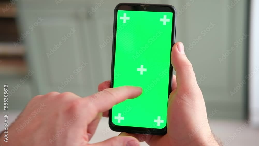 Man hand holding smartphone green mock-up screen. Close-Up. Male person ...