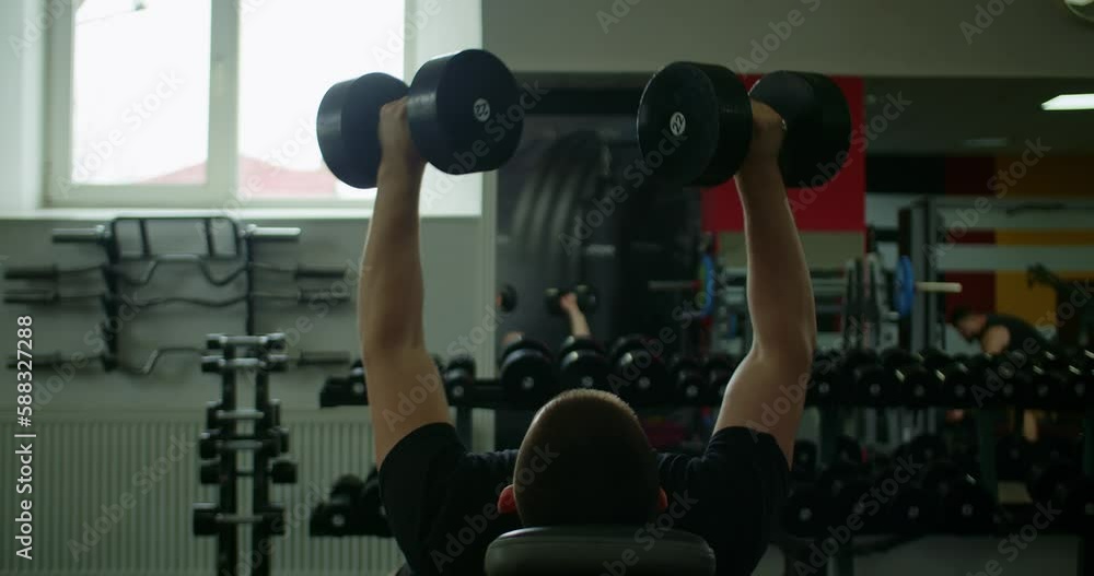 Muscular bodybuilder man lifting heavy weights black dumbbells. Gym ...