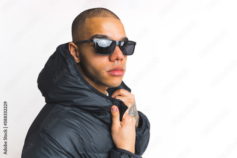 Serious confident male model in sunglasses and black puffer jacket ...