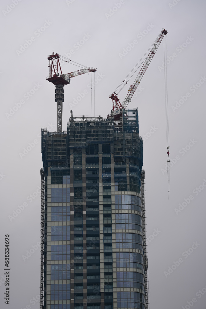 Foto de Construction site in Tokyo. Big cranes on a skyscraper modern ...