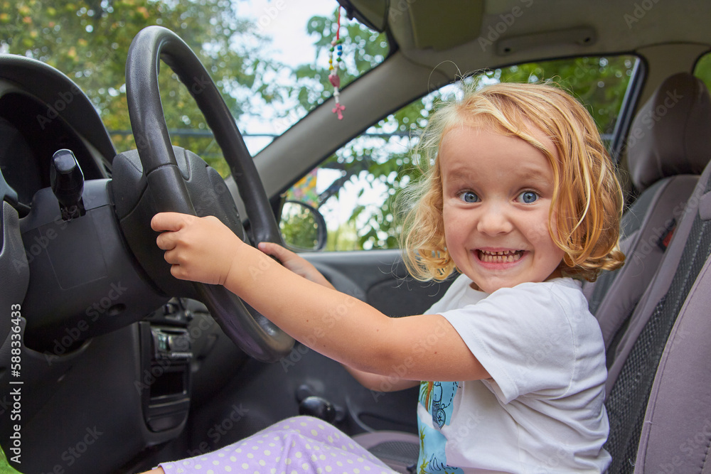 smiling little girl driving a car,a girl driving a car, a smiling child ...