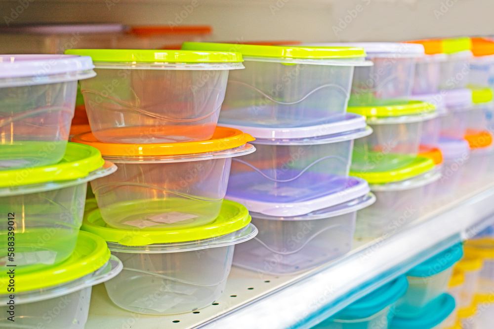 transparent plastic containers with colorful lids on the store counter ...