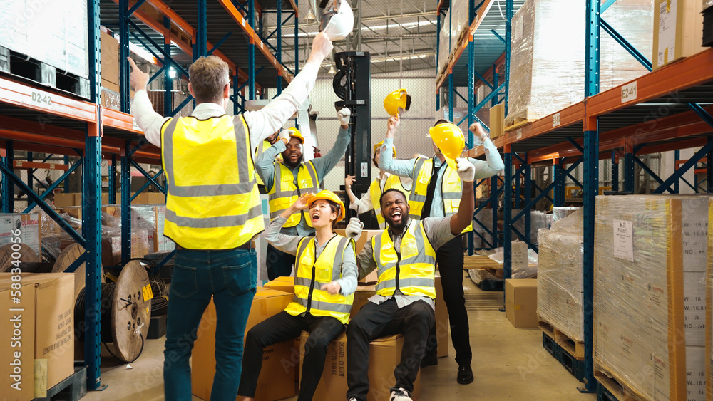 Multiracial warehouse workers in safety wear are stacking hands and ...
