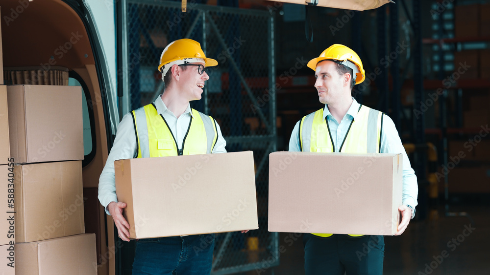 Portrait of two Caucasian warehouse workers in safety wear standing ...
