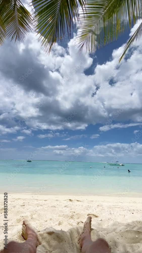 POV camera vertical video of relaxing man lying on sandy beach enjoying ...