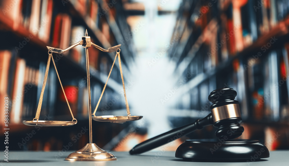 Shiny golden balanced scale and wooden gavel in court library ...