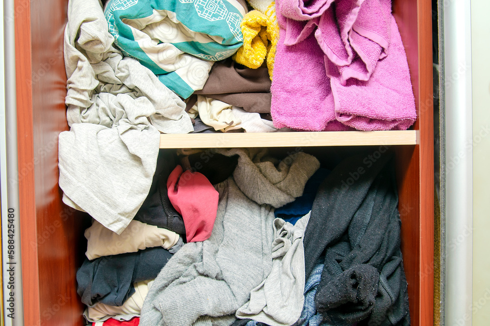 Messy closet filled with different used unfresh clothes, sloppily ...