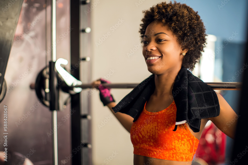 Fitness woman doing the barbell back squat using the power rack in a ...