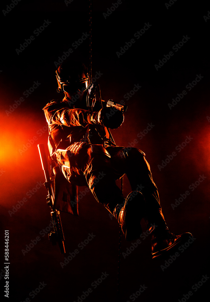 Foto de Silhouette of police officer in tactical gear descending from a ...