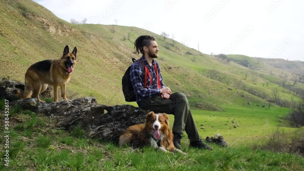 Vidéo Stock Young Caucasian man with dreadlocks went hiking with two ...