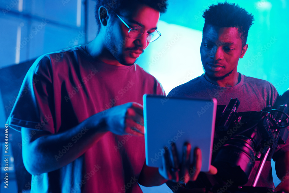 Director showing theme of shooting on digital tablet to photographer ...