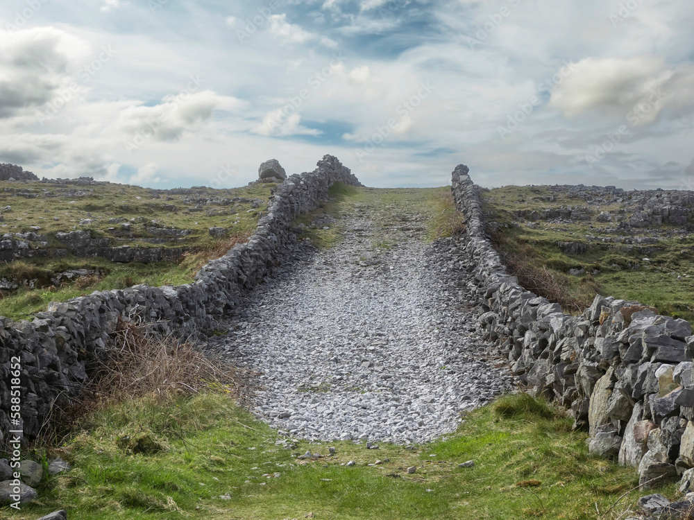 Small rough stone road up hill and fences and view on stunning ...