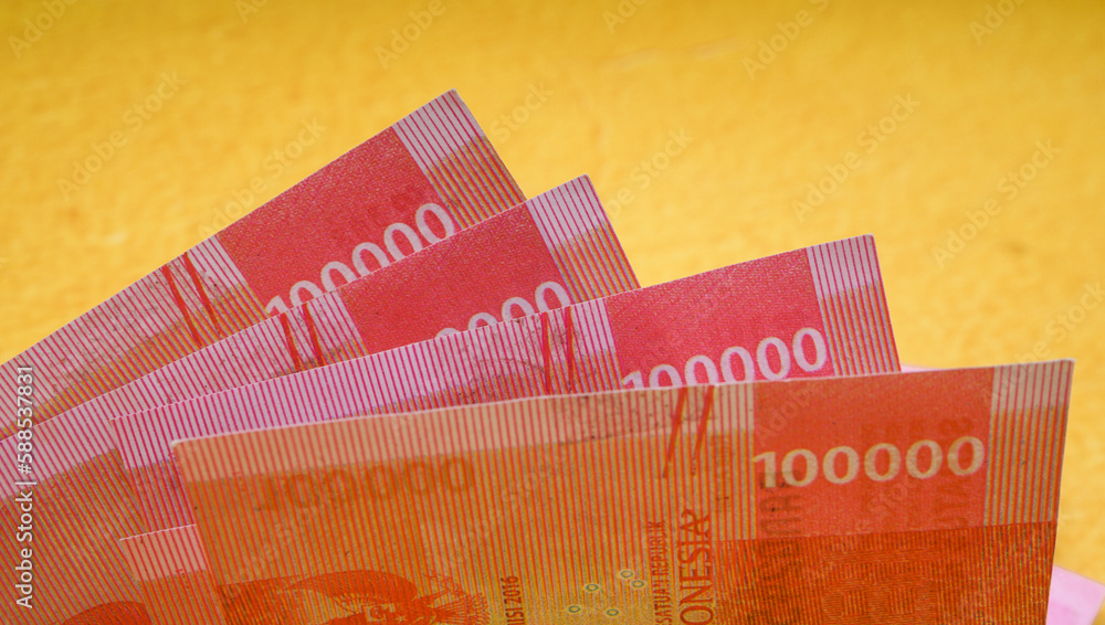 Rolled bundle of rupiah, currency of Indonesia on yellow backgrounds ...