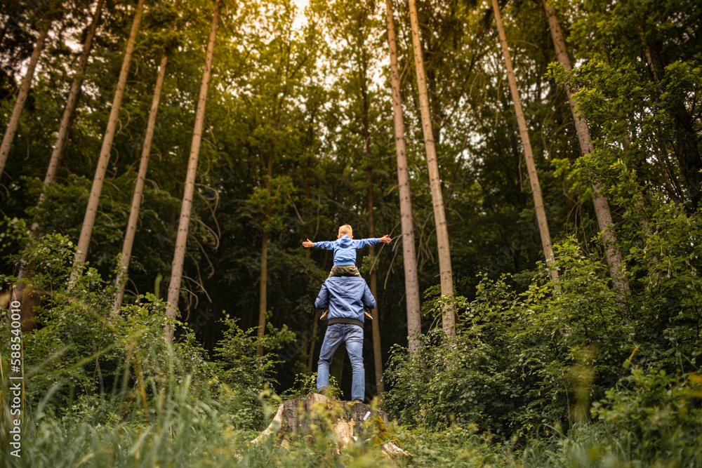 Happy father and son on a fun adventure standing in a pine forest ...